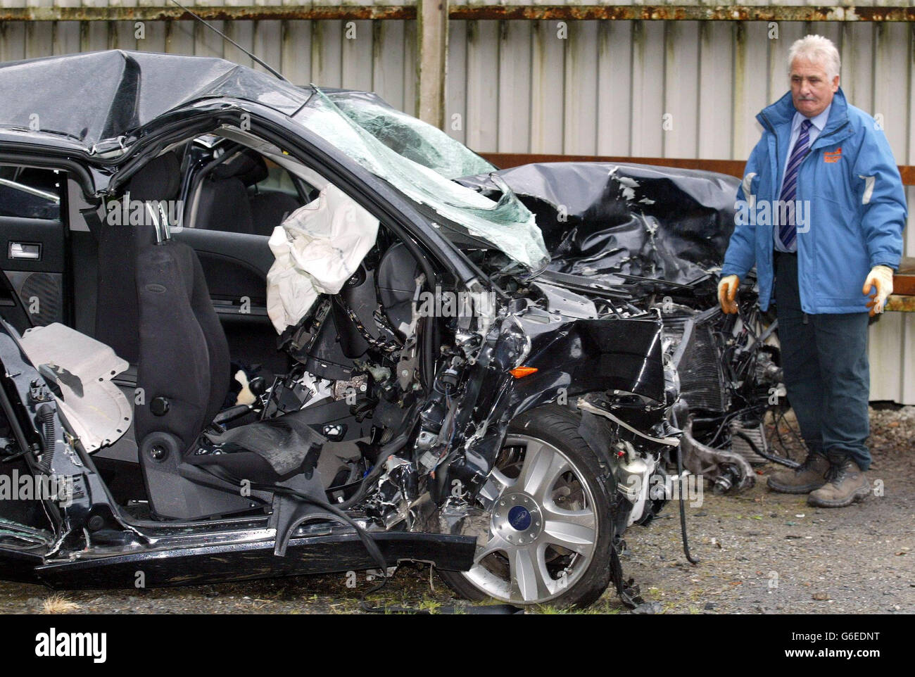 A member of staff looks at the remains of the Ford Mondeo and Audi, at ...