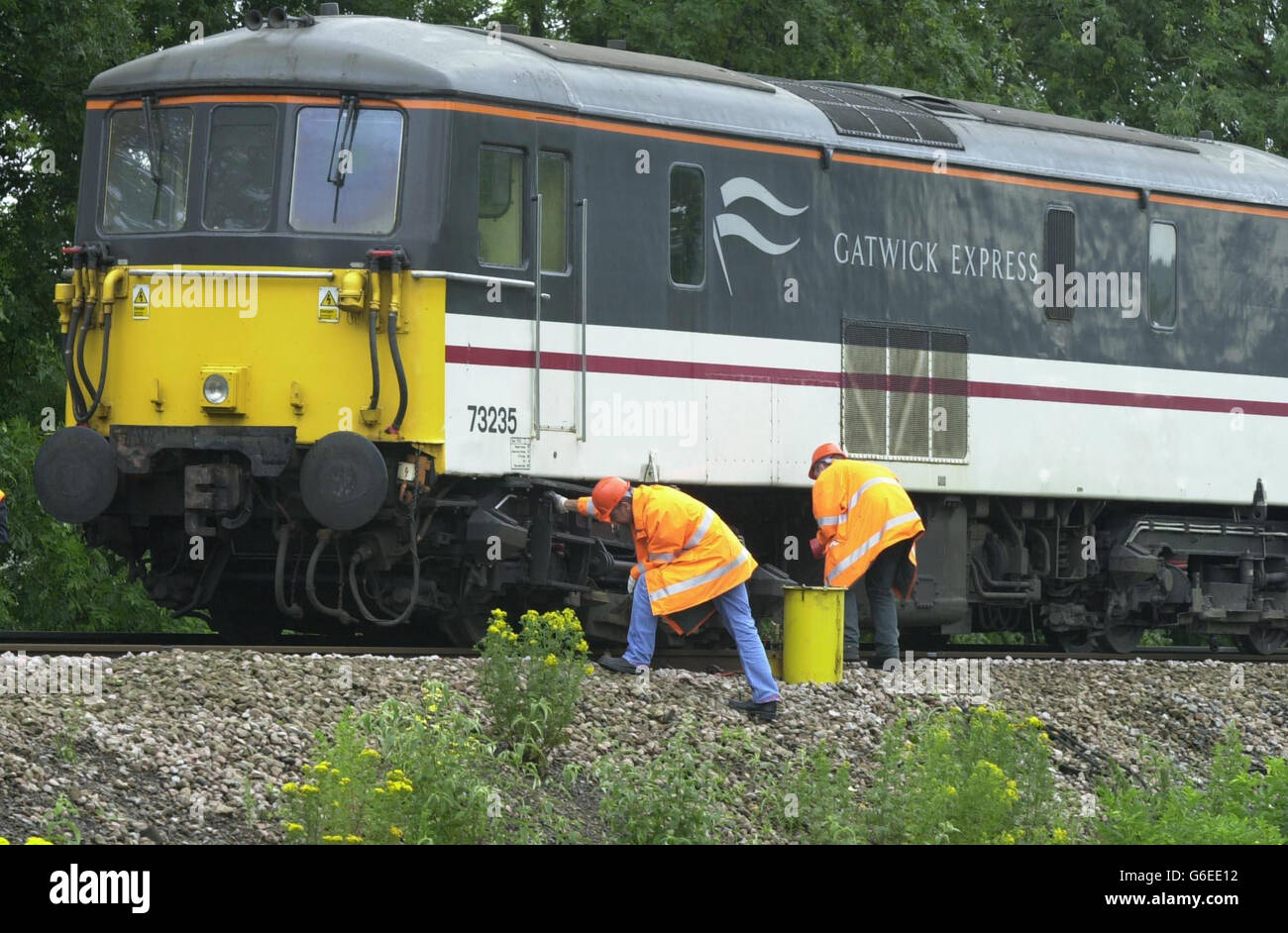 Engineers examine the derailed bogie of the rear locomotive of the ...