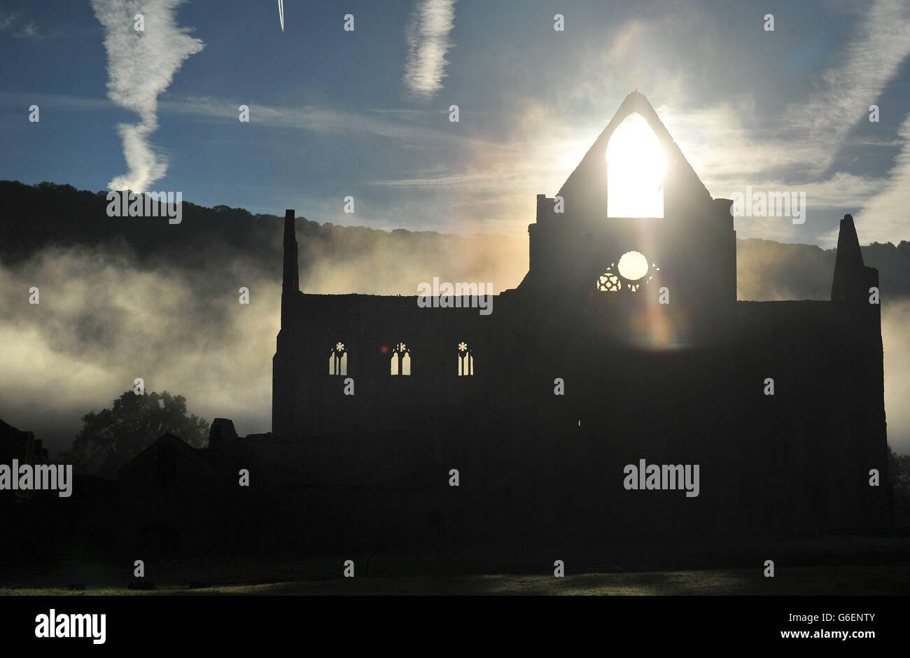 The Autumn sun rises behind Tintern Abbey in the Wye Valley Stock Photo ...