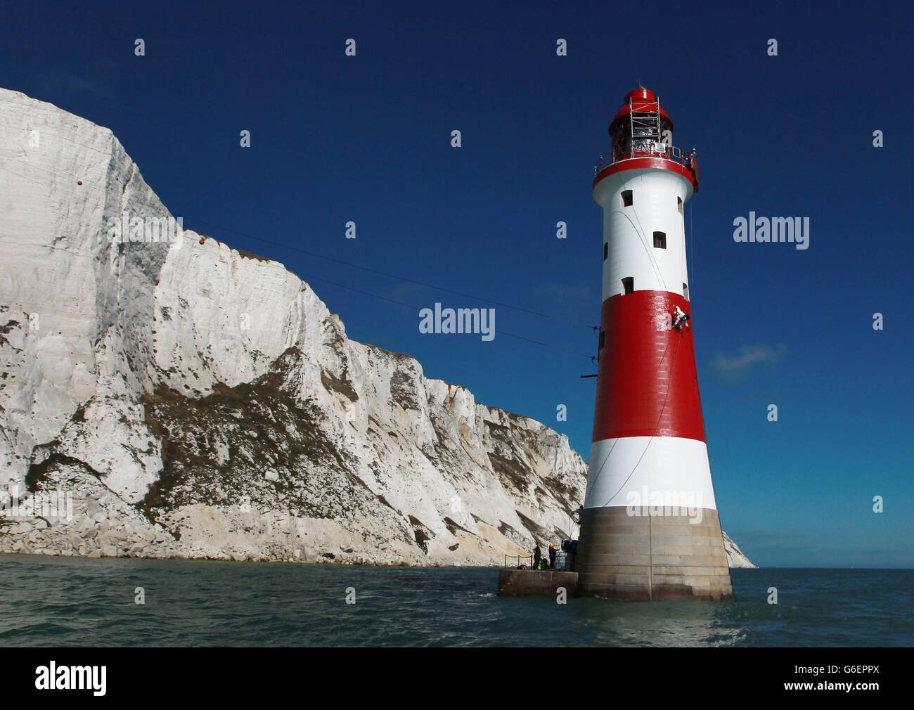 Specialist abseiler Ian Bell is suspended from Beachy Head Lighthouse ...