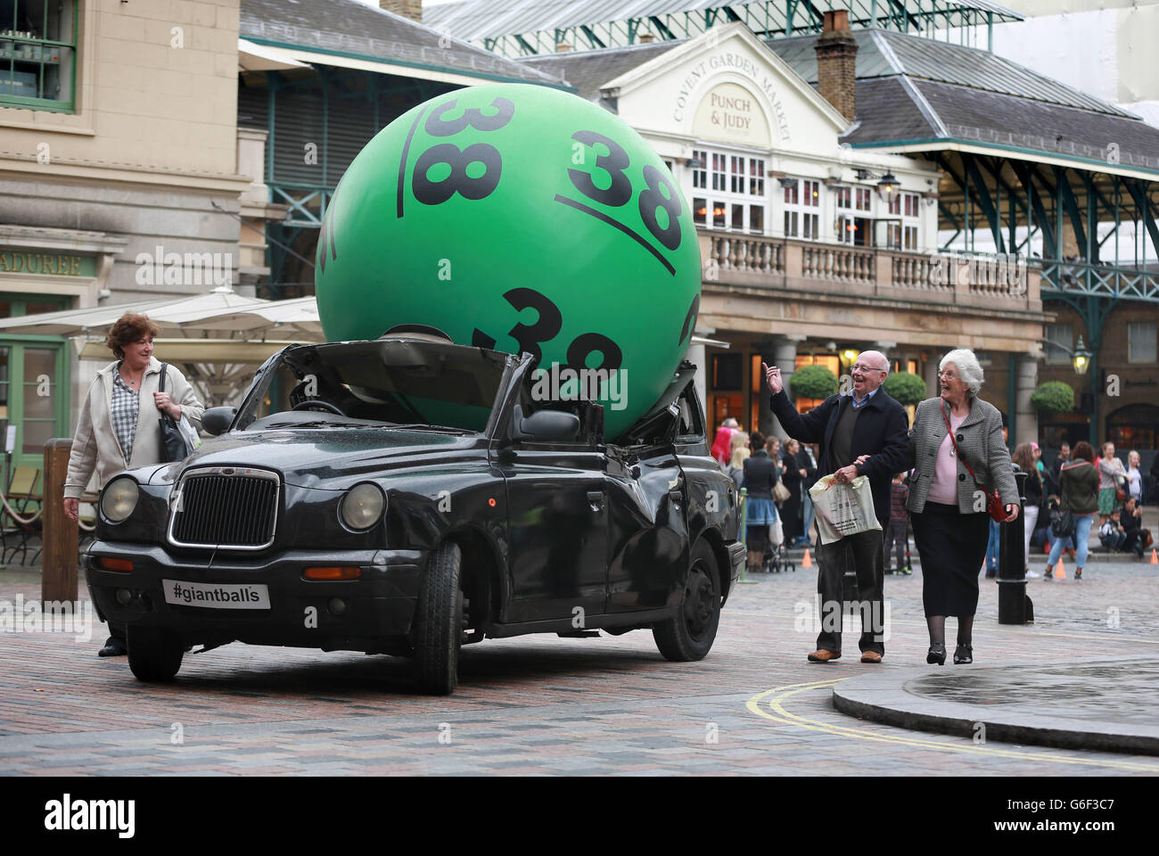 Joe and Glenys Groom from Anglesey walk past a giant Lotto ball that ...
