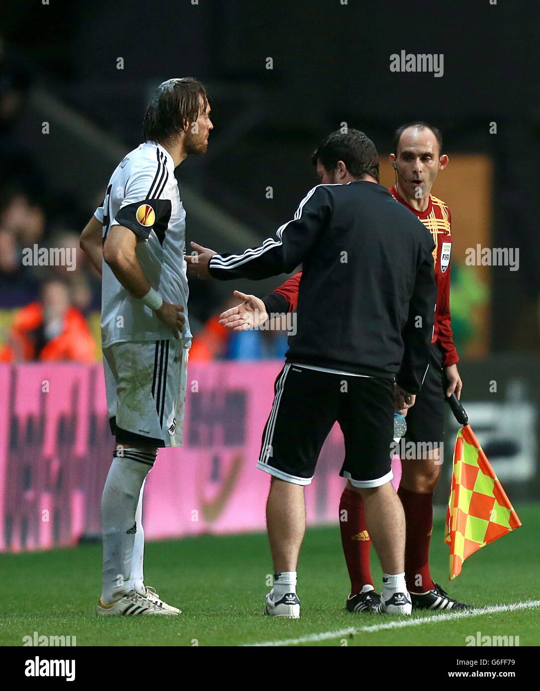 Swansea City's Miguel Michu (leftt) complains to the fourth official ...
