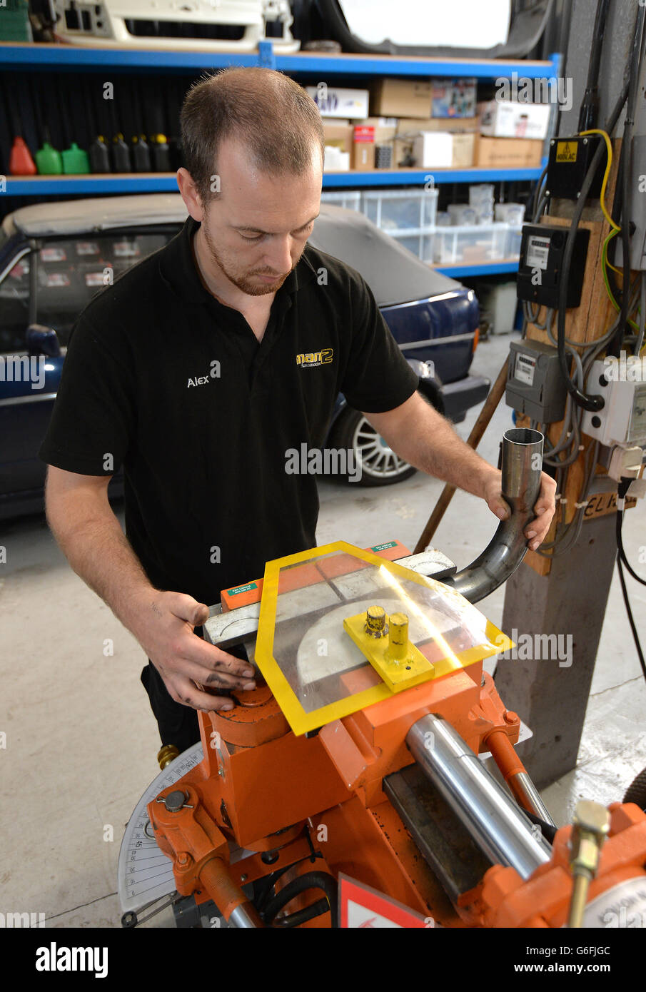 A mechanic bends a piece of stainless steel exhaust piping hi-res stock ...