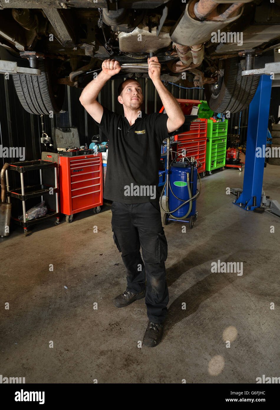 A Mechanic works on the sump underneath a Bentley car Stock Photo - Alamy