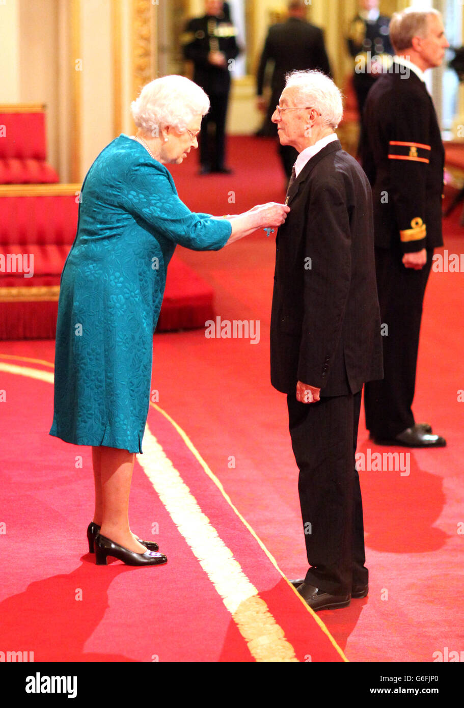 Richard Glasstone receives an MBE from Queen Elizabeth II at an ...