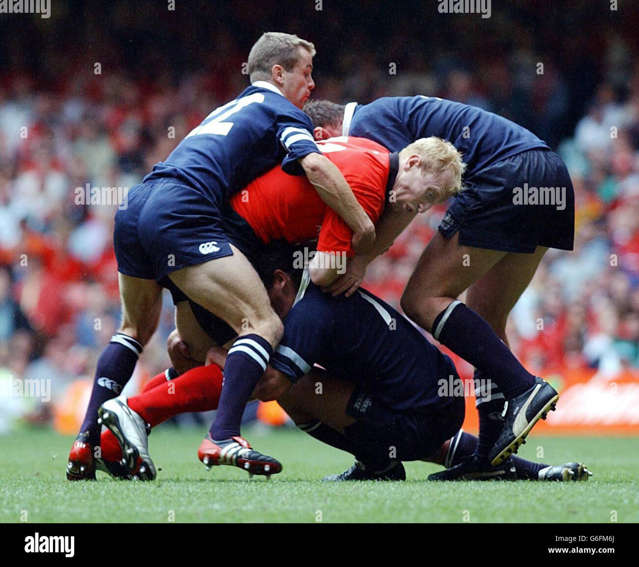 Wales's Tom Shanklin is wrapped up by Scotland's Brendan Laney and ...