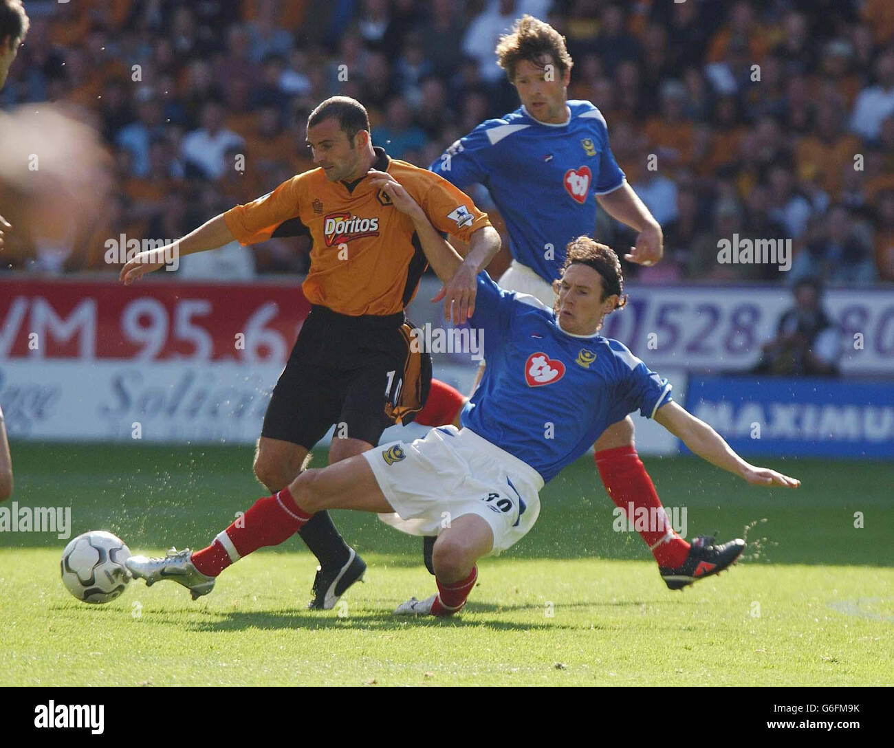 Portsmouth's Alex Smertin (centre) slides in on Colin Cameron of ...