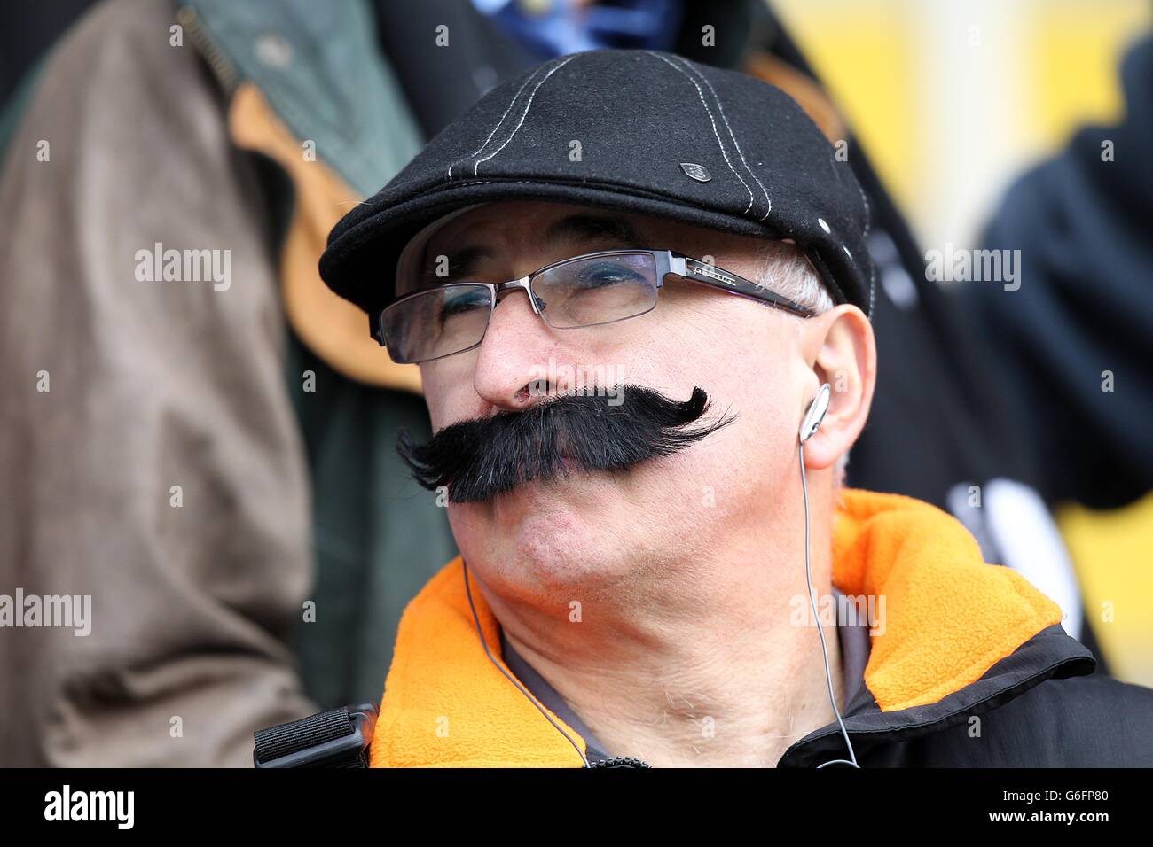 A fan wears a fake moustache in honour of Fulham Ownwer and Chairman ...