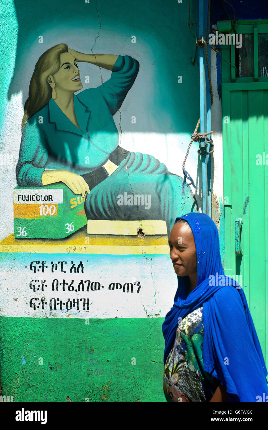 Harari woman in the street in muslim dress walkign past Fujicolour film ...