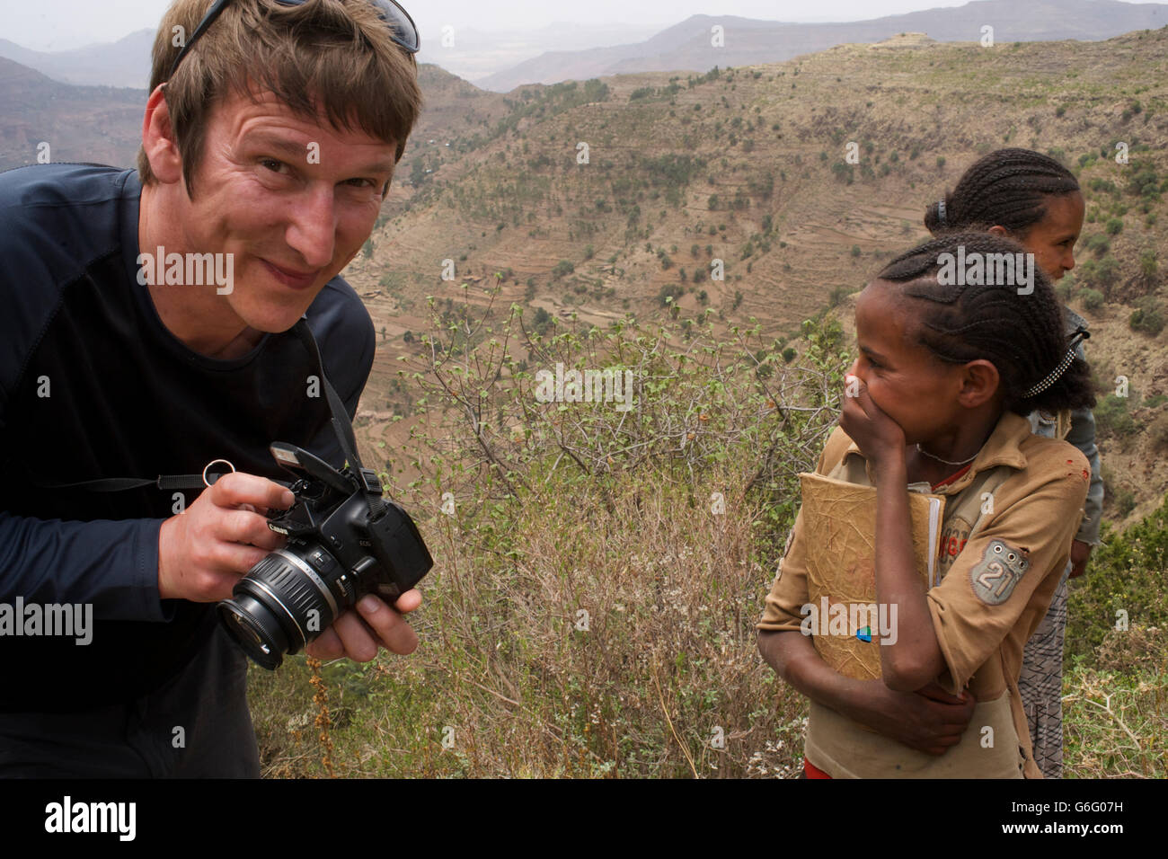 Western traveller sharing his digital photographs with Ethiopian kids ...