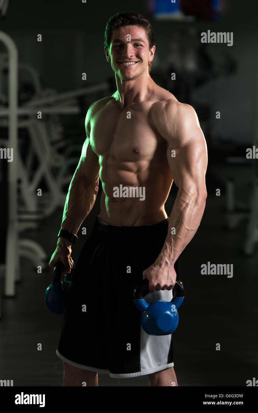 Young Man Exercising With Kettle Bell And Flexing Muscles - Muscular ...