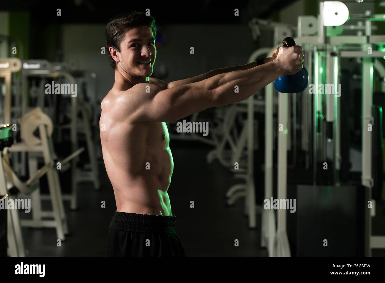 Young Man Exercising With Kettle Bell And Flexing Muscles - Muscular ...