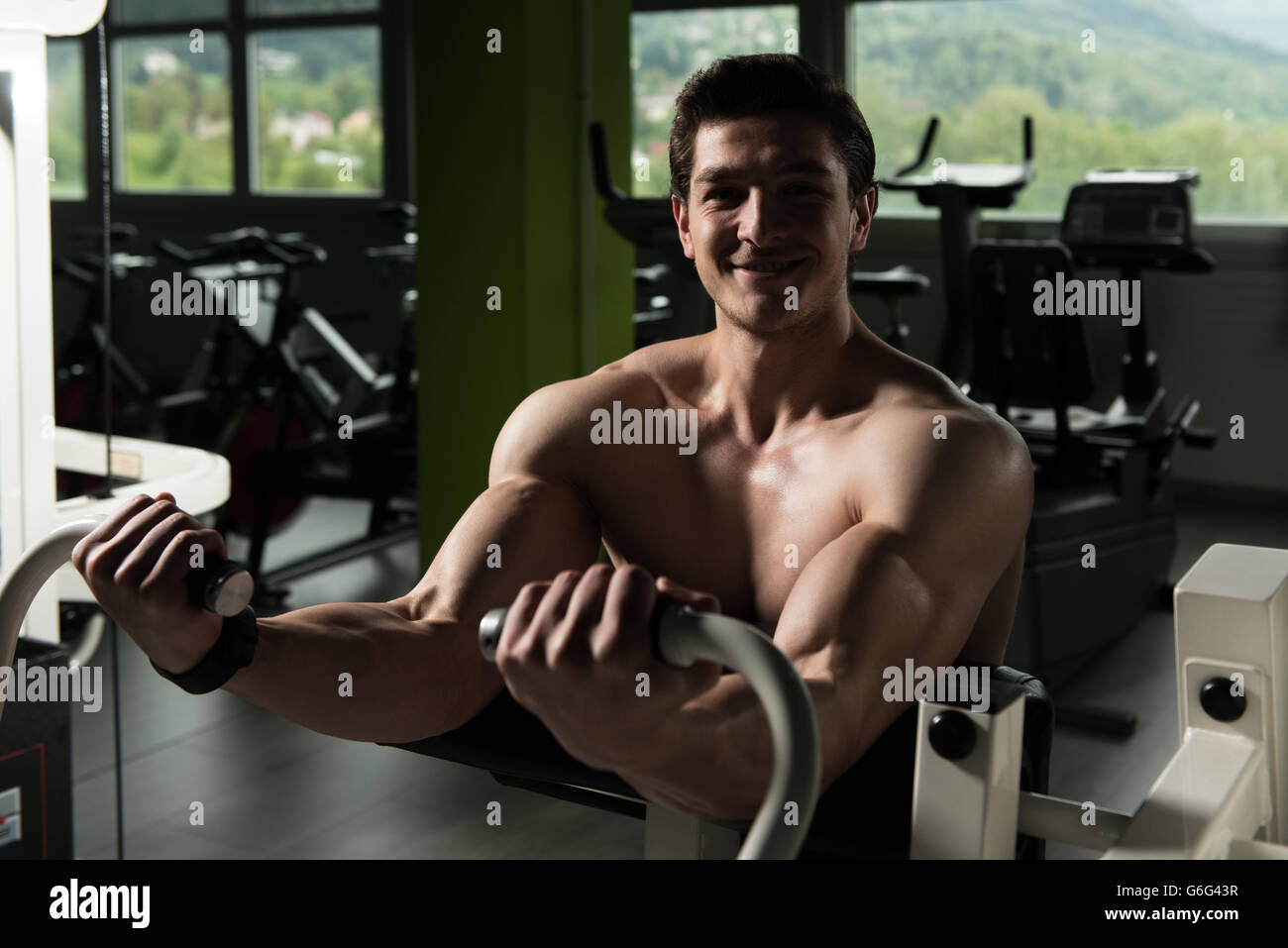 Biceps Exercise Machine - Young Bodybuilder Doing Heavy Weight Exercise ...