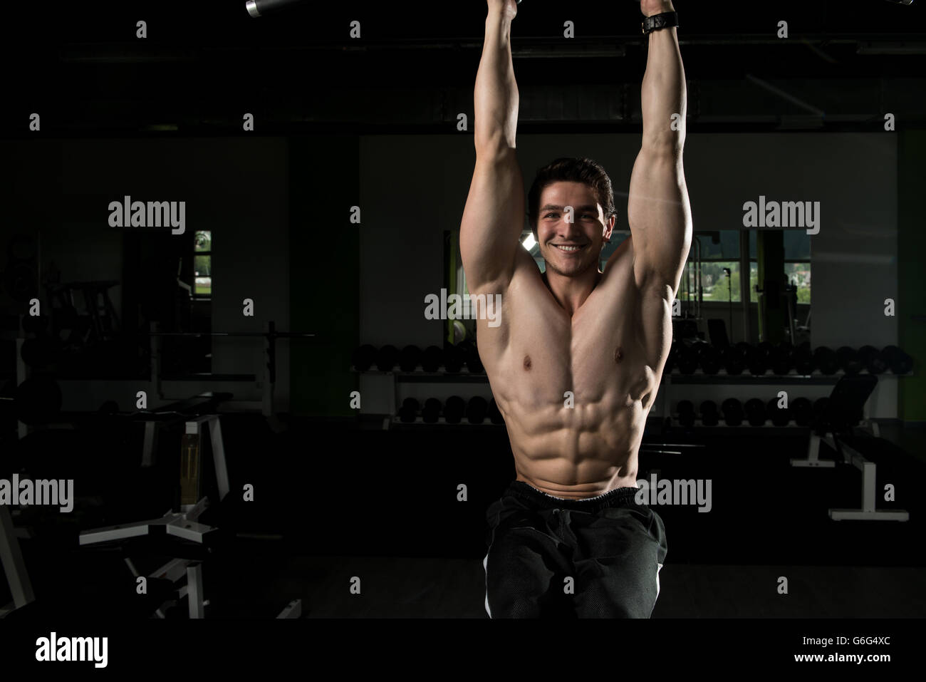 Young Man Performing Hanging Leg Raises Exercise - One Of The Most ...