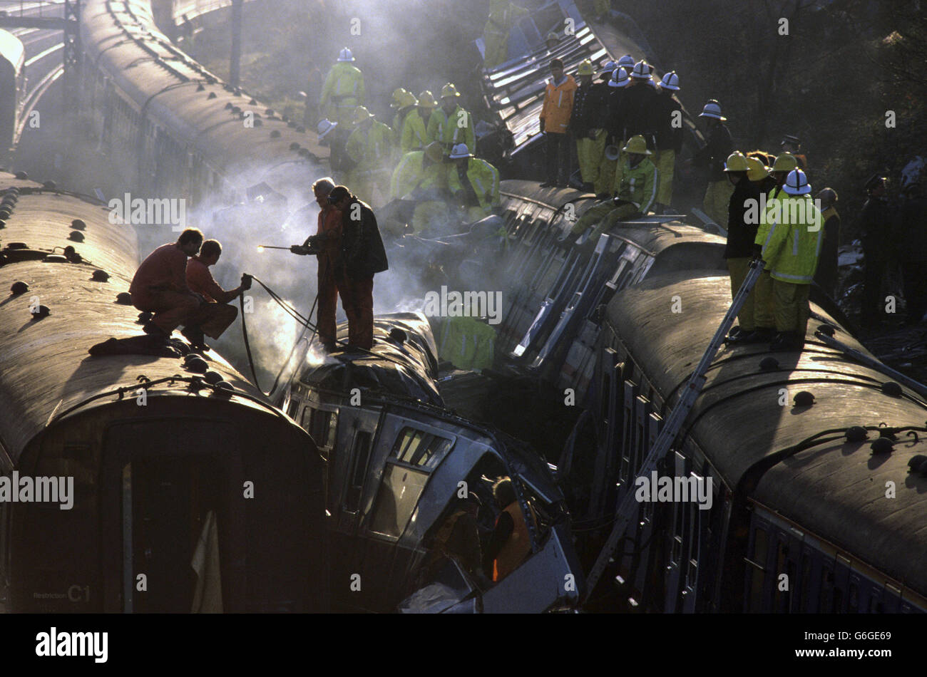 Rescue workers clamber over the wreckage of three trains that crashed ...