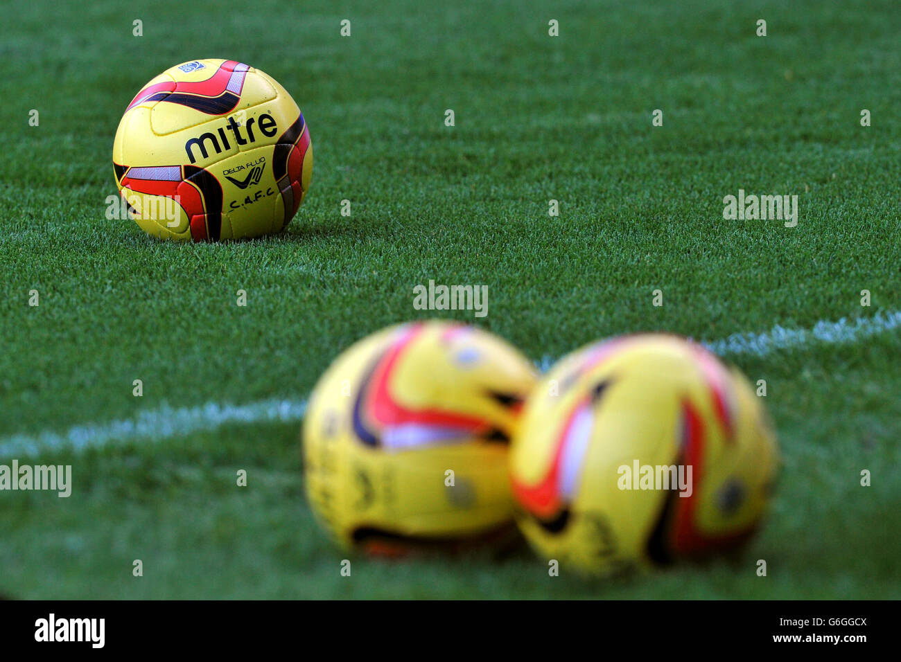 Yellow mitre footballs lie on pitch hi-res stock photography and images ...