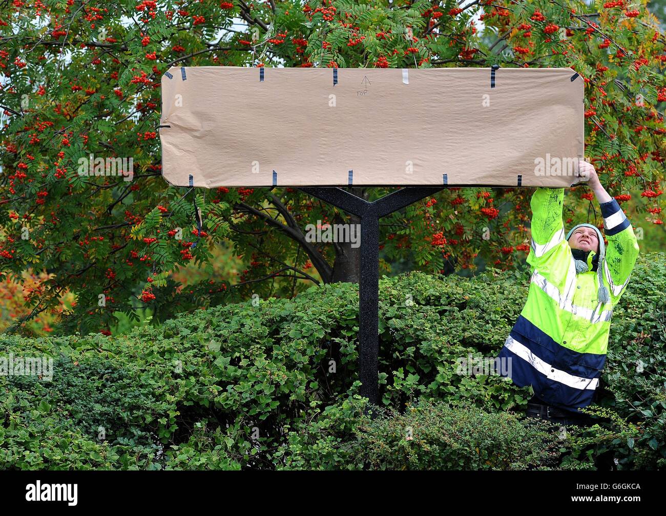 A Council worker unveils a street sign after a ceremony to mark the ...