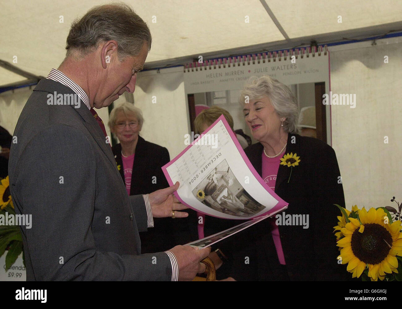 The Prince of Wales looks at a copy of the famous WI Calendar Girls new ...