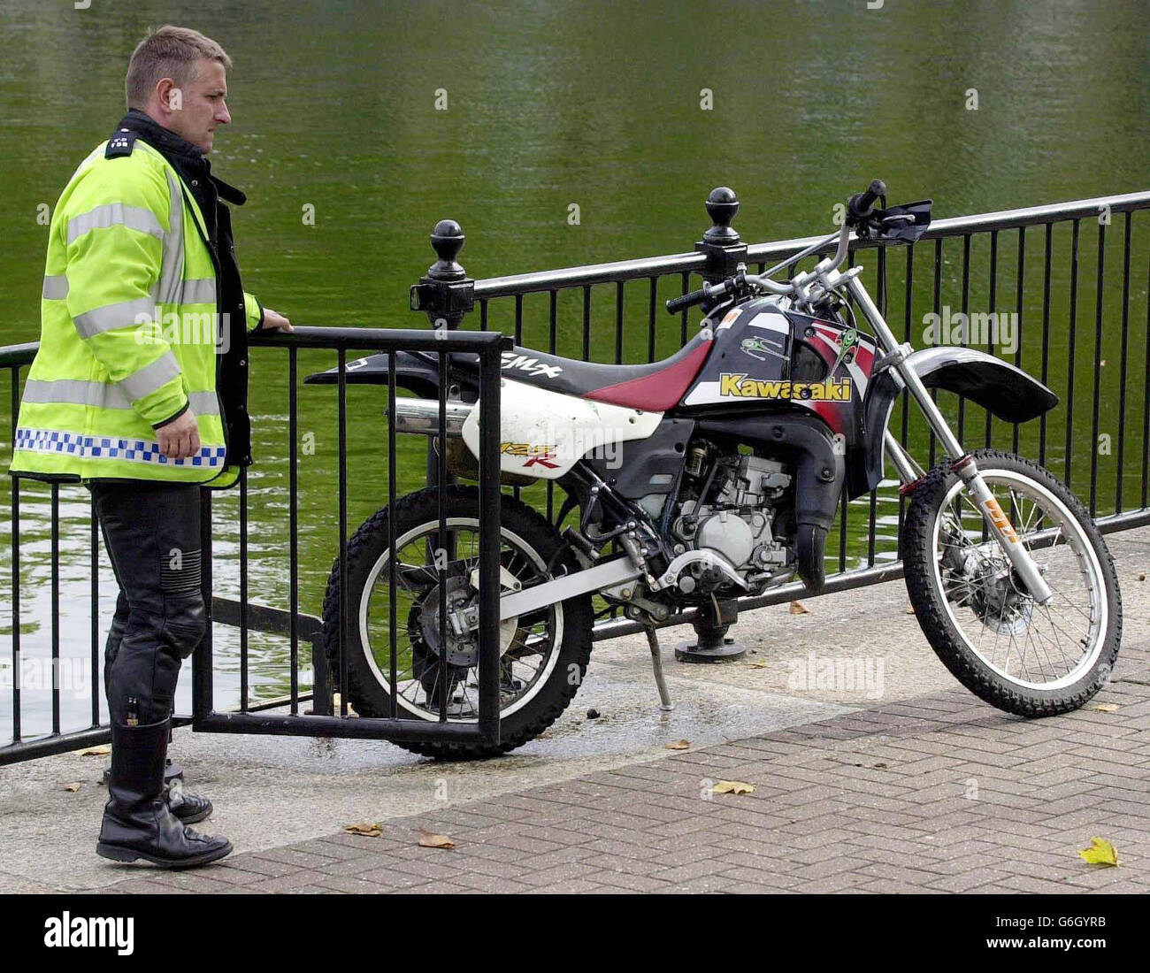 A police officer stands next to a motorcycle after it was retrieved ...