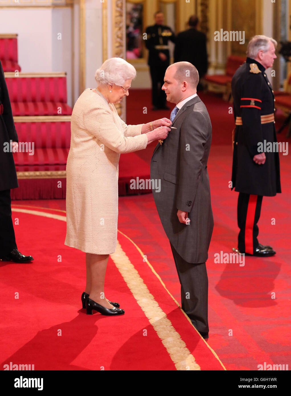 Mr. John Gilhooly from London is made an OBE by Queen Elizabeth II at ...