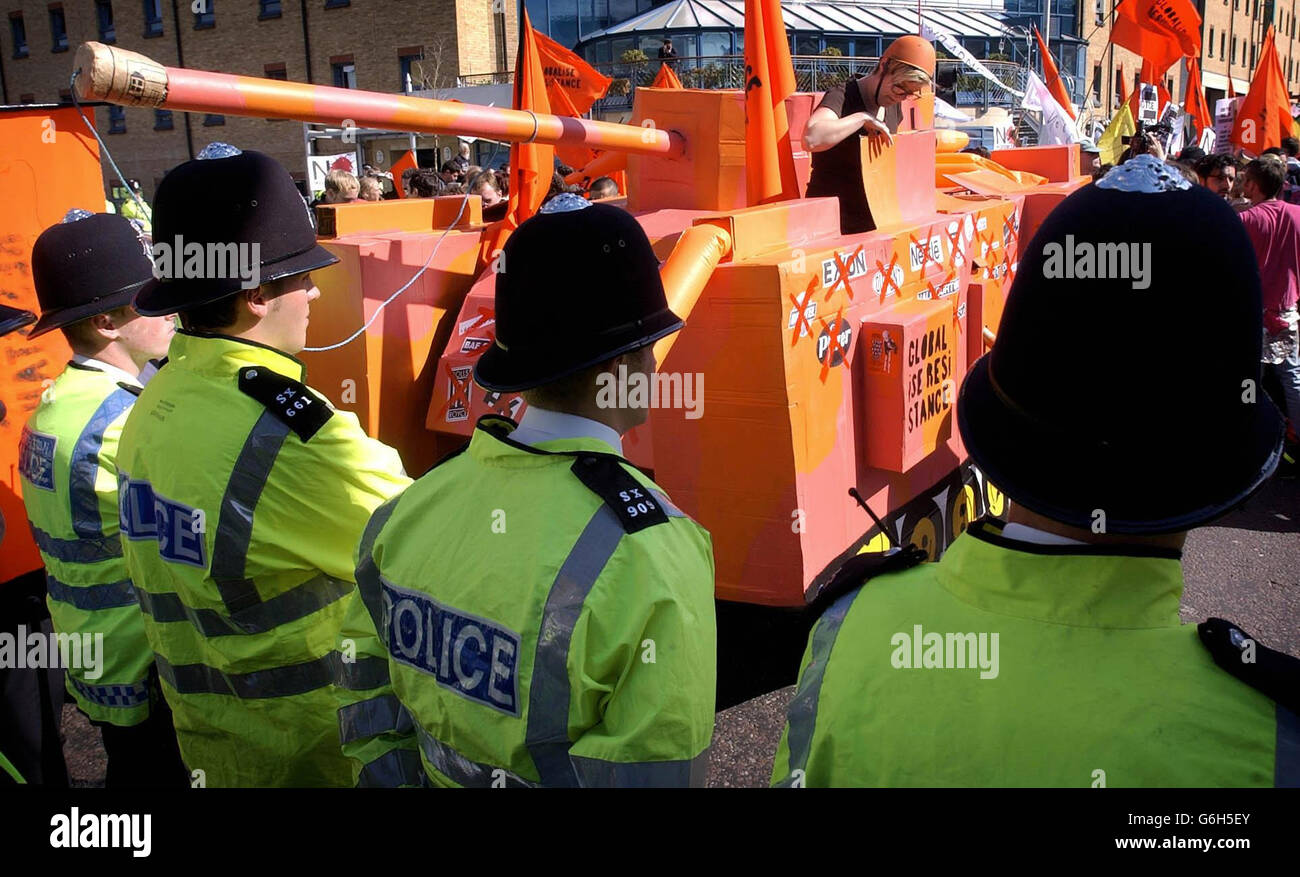 Demonstrators push a pink wooden tank in front of a line of police ...