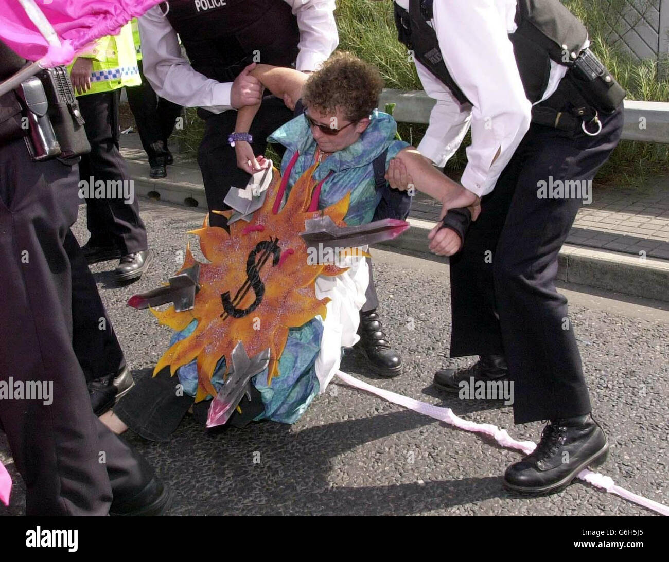 A protestor is led away by police officers , during a march against the ...