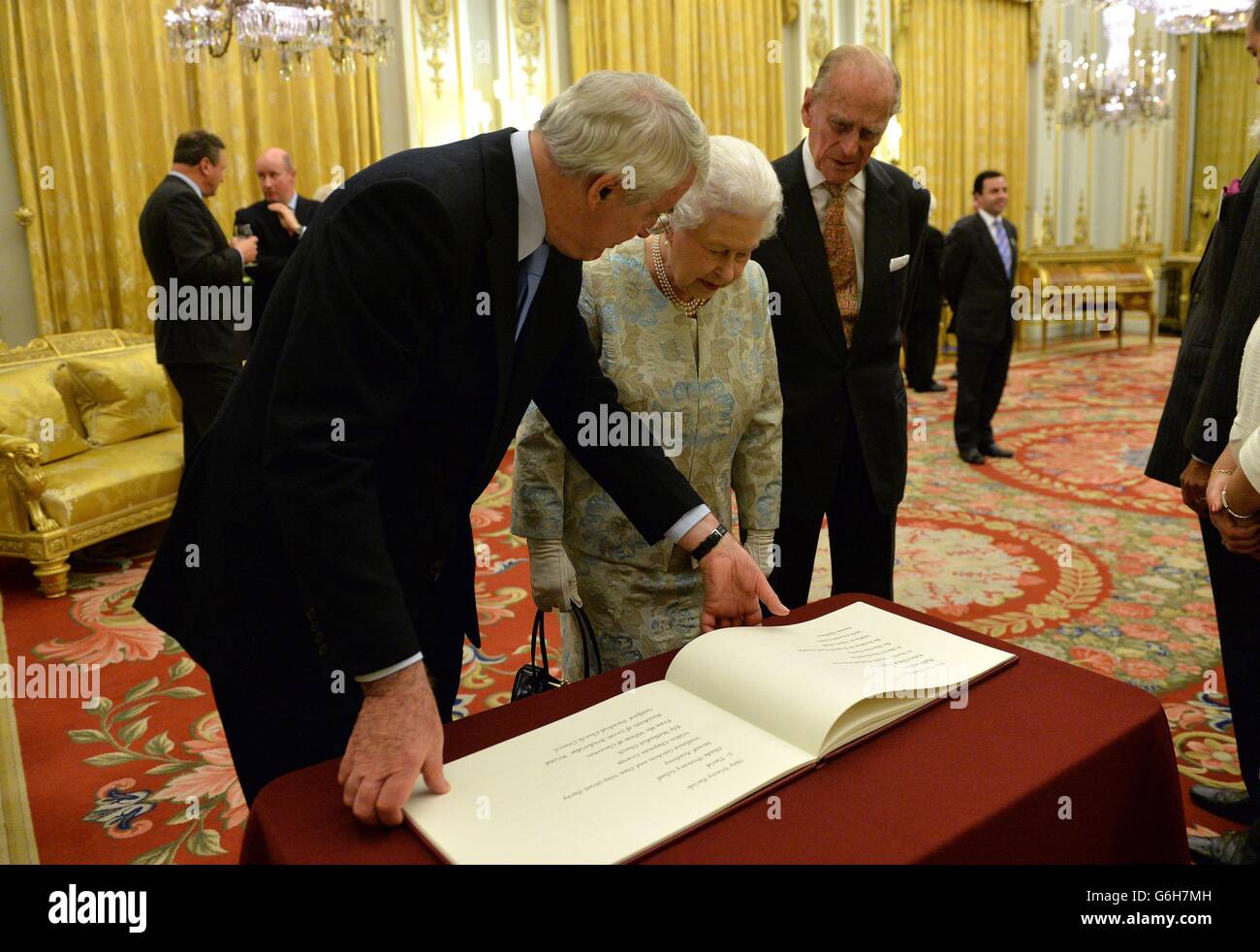 Queen Elizabeth II and Sir John Major (left) inspect a book, as the ...