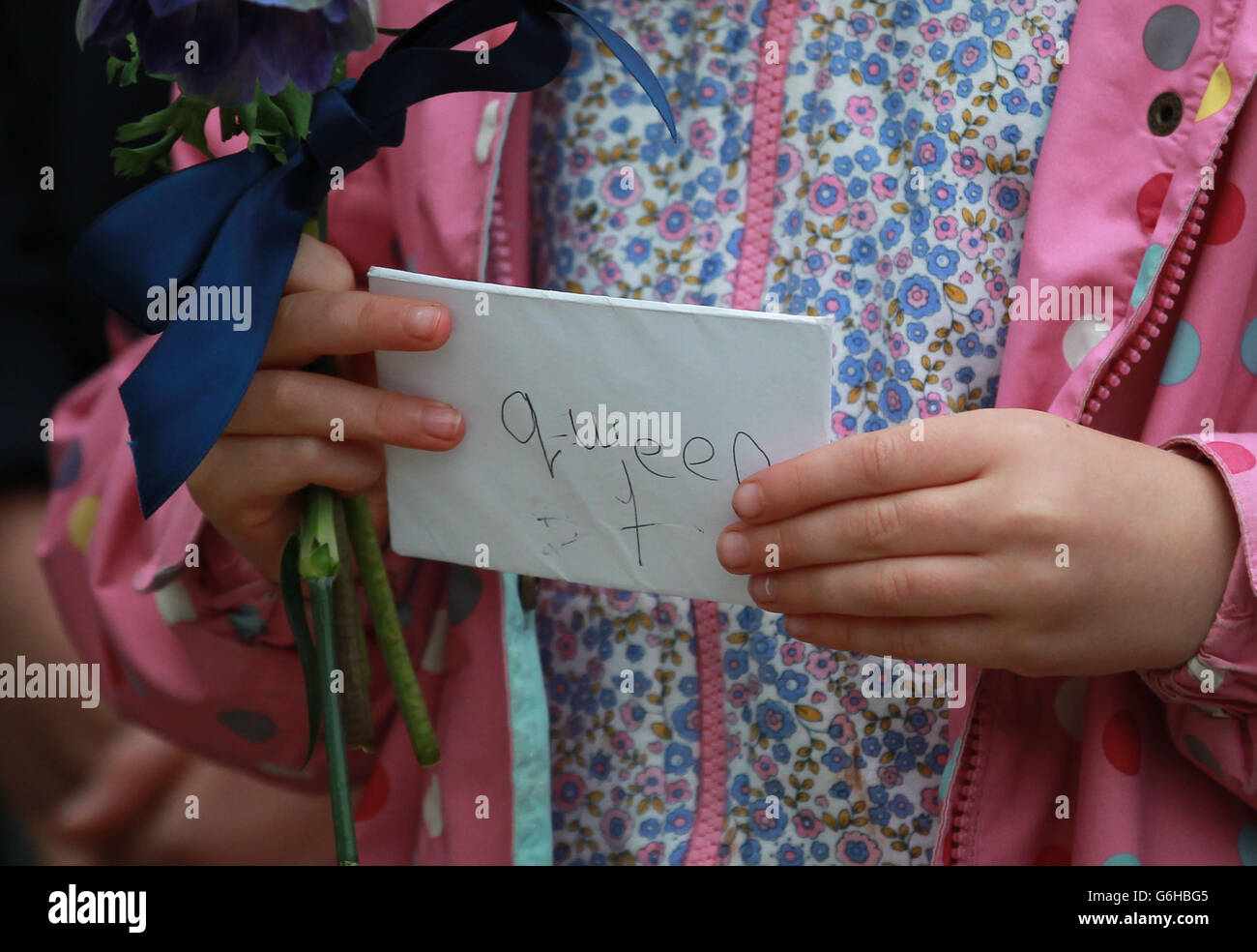 A school girl holds a hand written note for Queen Elizabeth II as she ...