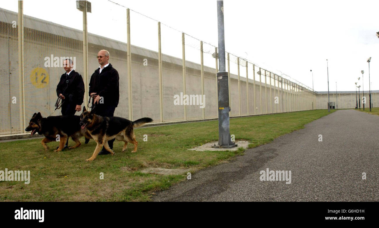 Dog handling officers patrol at the high security local prison hi-res ...