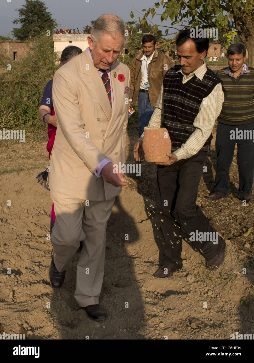 The Prince of Wales sows rice seed during a visit to the Navdanya ...