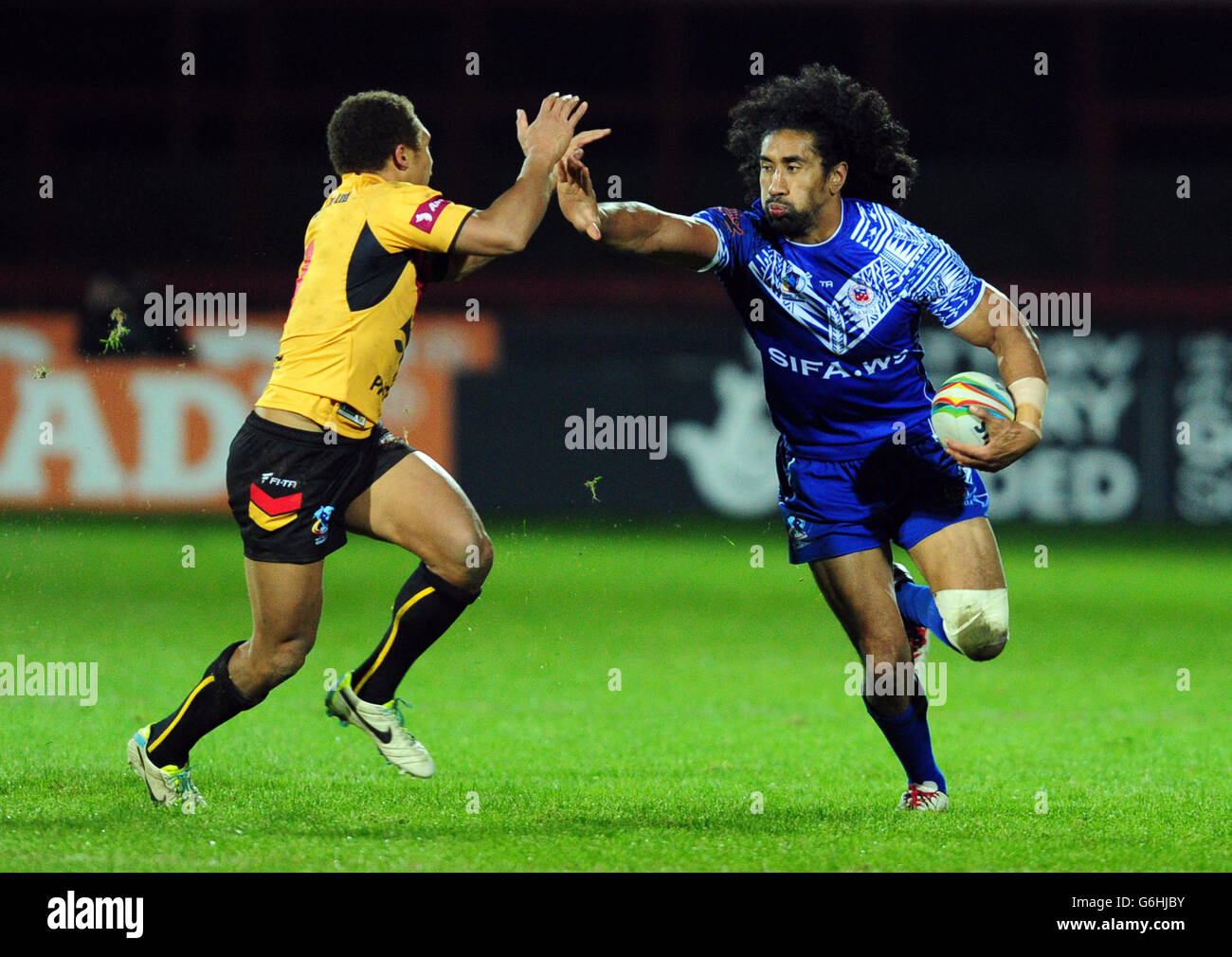 Samoa's Iosia Soliola (right) holds off Papa New Guinea's Ray Thompson ...