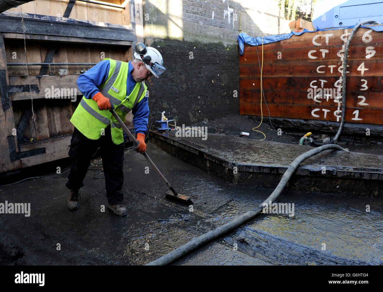 A maintenance workers sweeps away away silt during an open event as ...