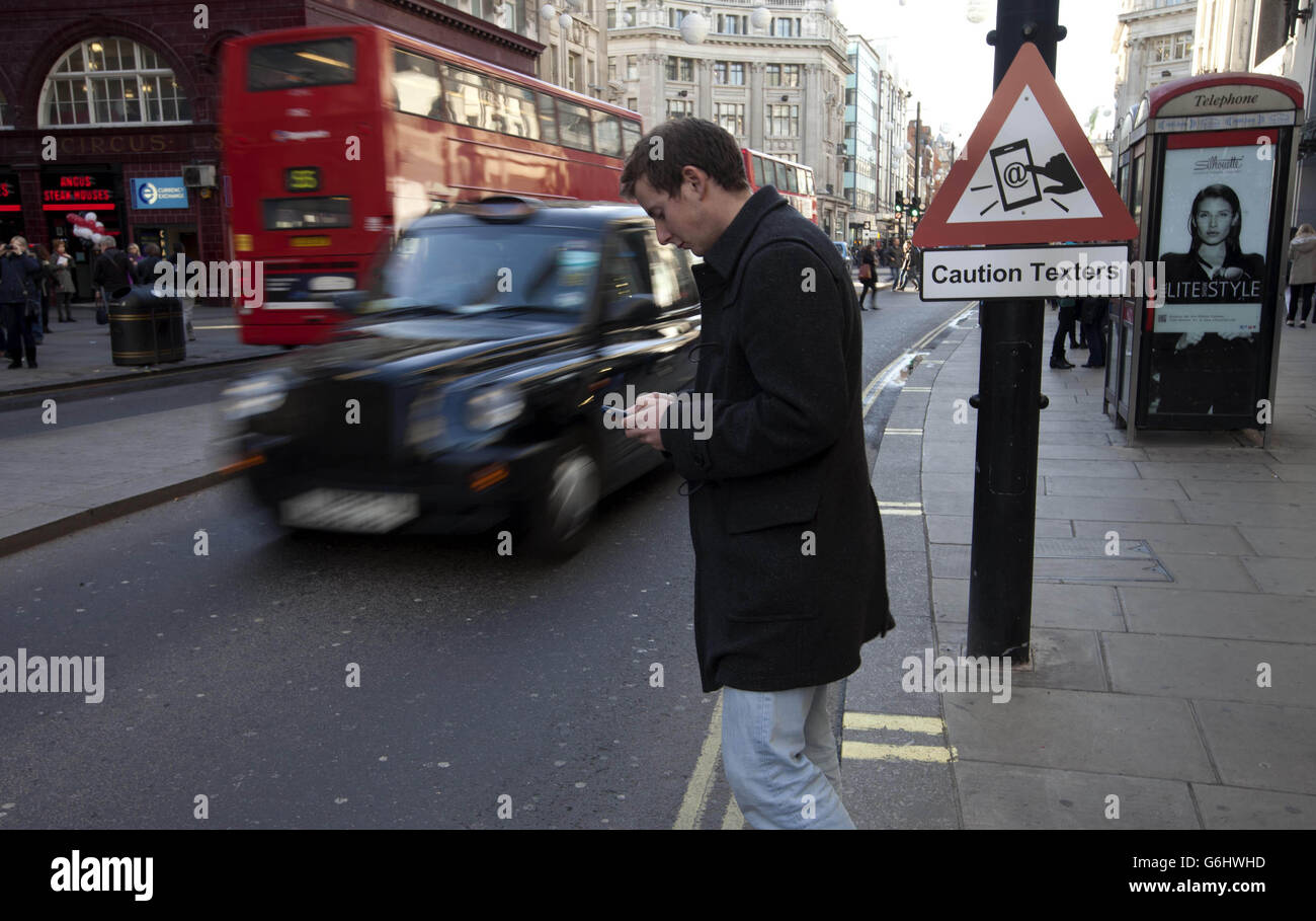 with warning 'Caution Texters', positioned on a London street to ...
