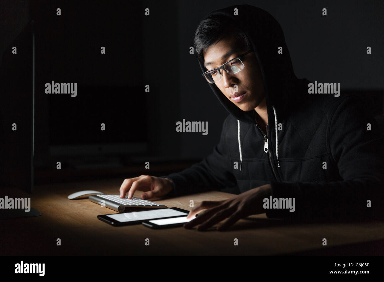 Thoughtful young man using computer, blank screen tablet and mobile ...