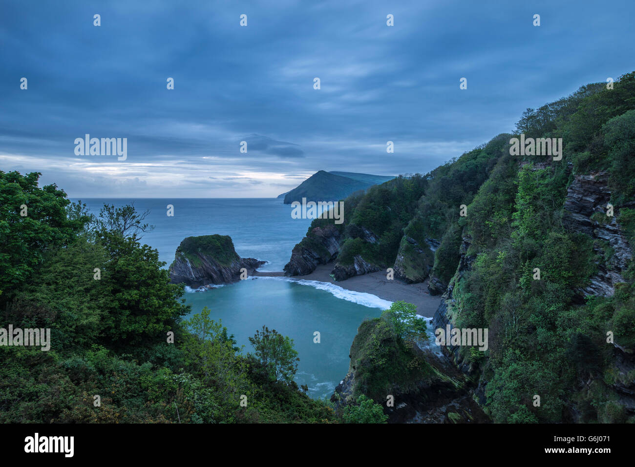 Beautiful moody sunrise landscape image of small secluded cove at Combe ...