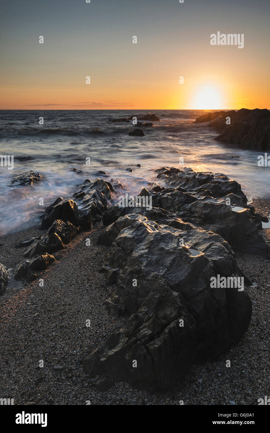 Beautiful sunset landscape image of calm sea against rocky shoreline ...