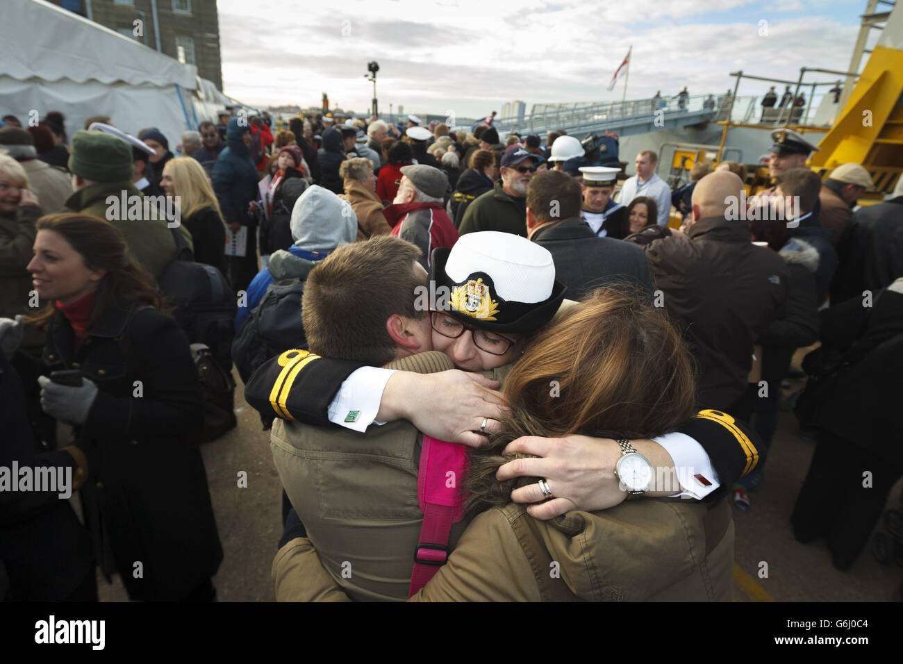 A sailor is greeted by her family as her ship-mates look for theirs ...