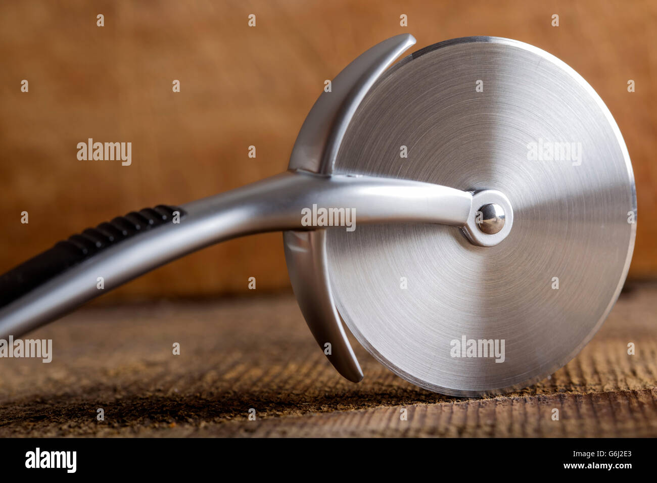 Circular Pizza Cutter on wooden rustic background Stock Photo - Alamy