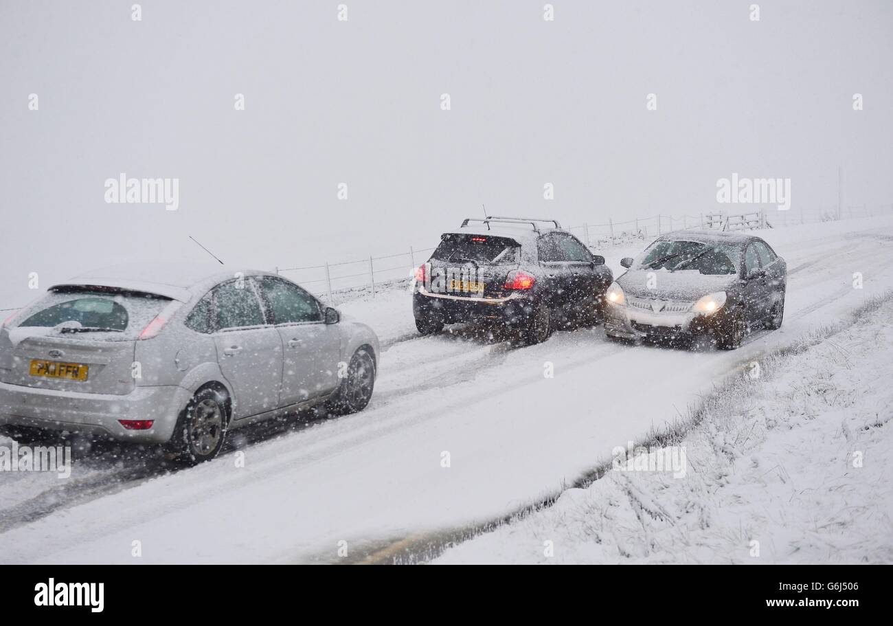 Cars travel along a snow covered road near Hartside on the Cumbria ...