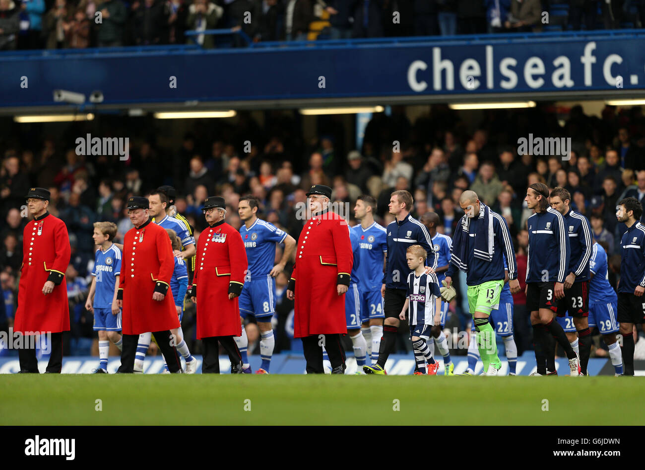 The teams are led out by Chelsea Pensioners to observe a minutes ...