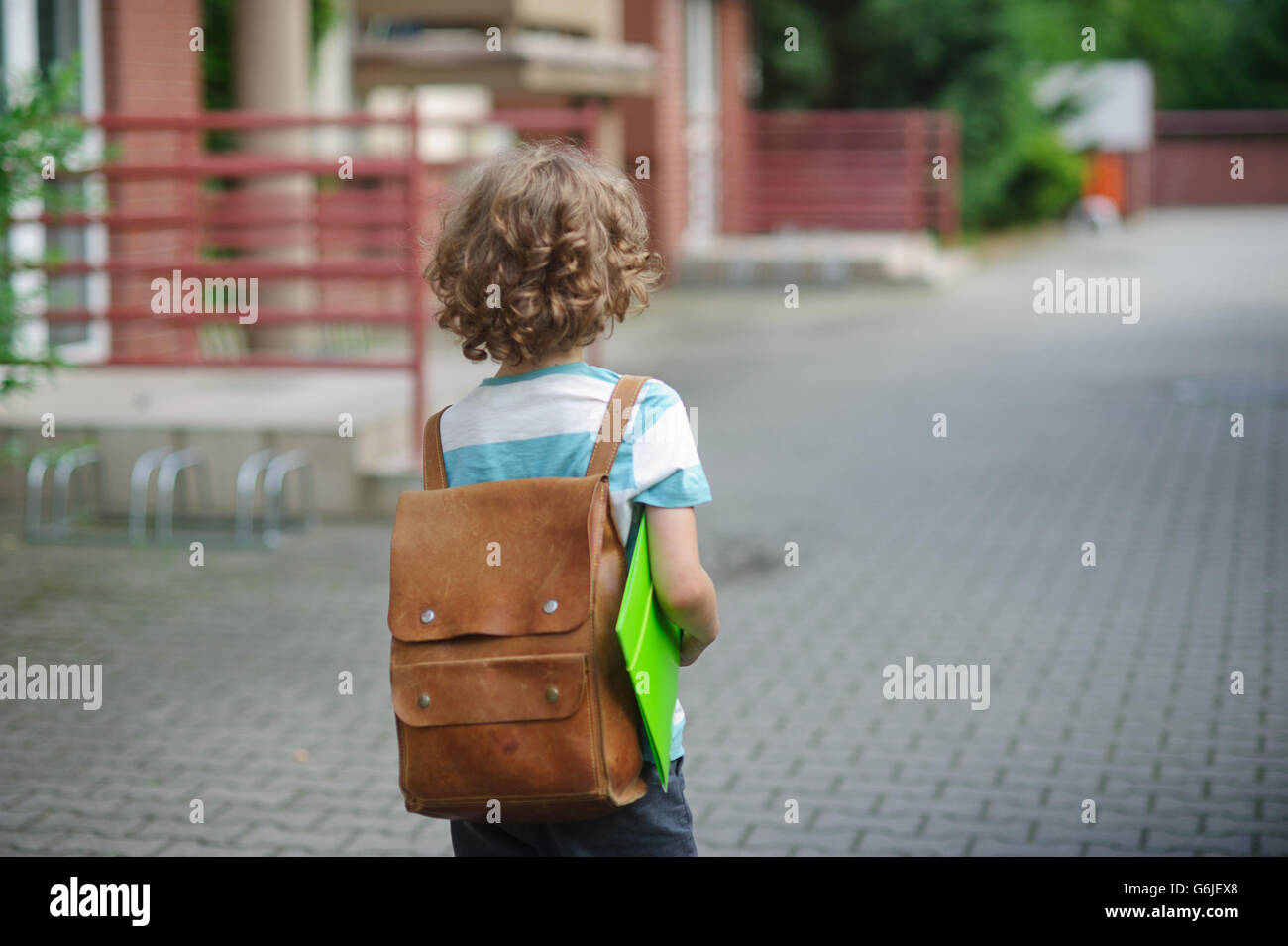 The schoolboy with a satchel on his shoulders and a folder in his hand ...