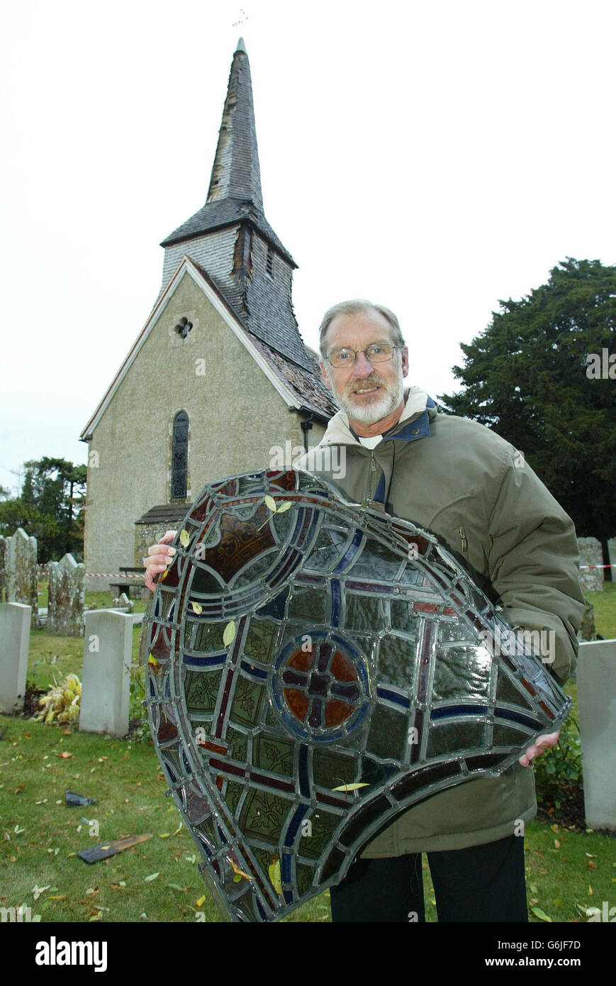 Canon Colin Fowler holds a piece of the stained glass window that was ...