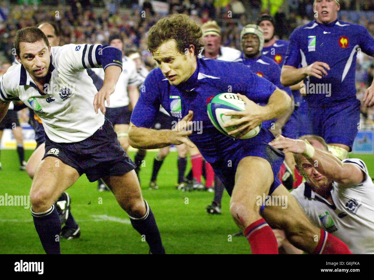 France's Fabien Galthie (centre) shakes off Scotland's Gregor Townsend ...