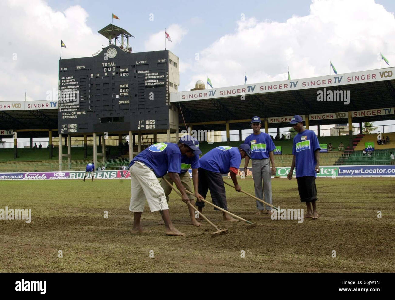 Ground staff work on the outfield after heavy rain yesterday at the ...