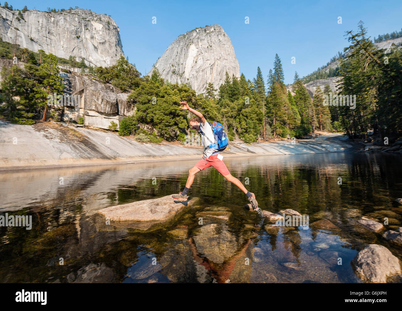 Young man jumping between stones, Merced River, Liberty Cap, Mist Trail ...