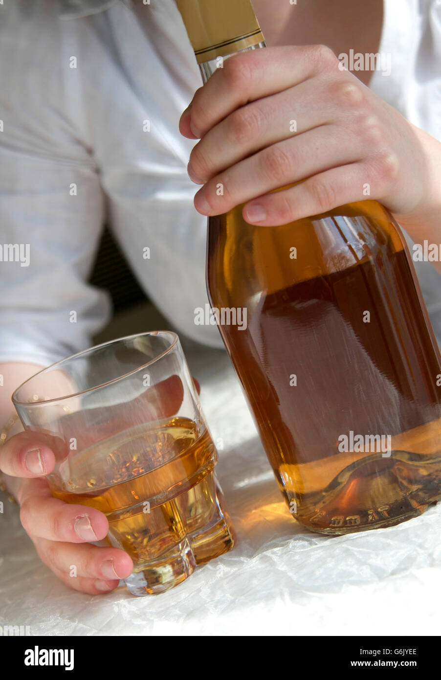 Woman's hands holding a bottle and a glass of hard liquor, female ...