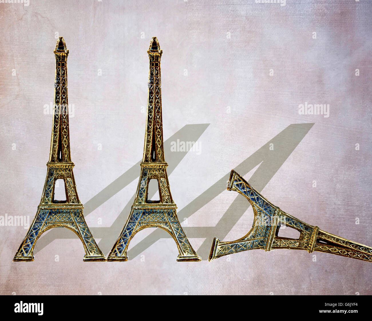 Three miniature Eiffel Towers shaped like the letter A, one toppled ...