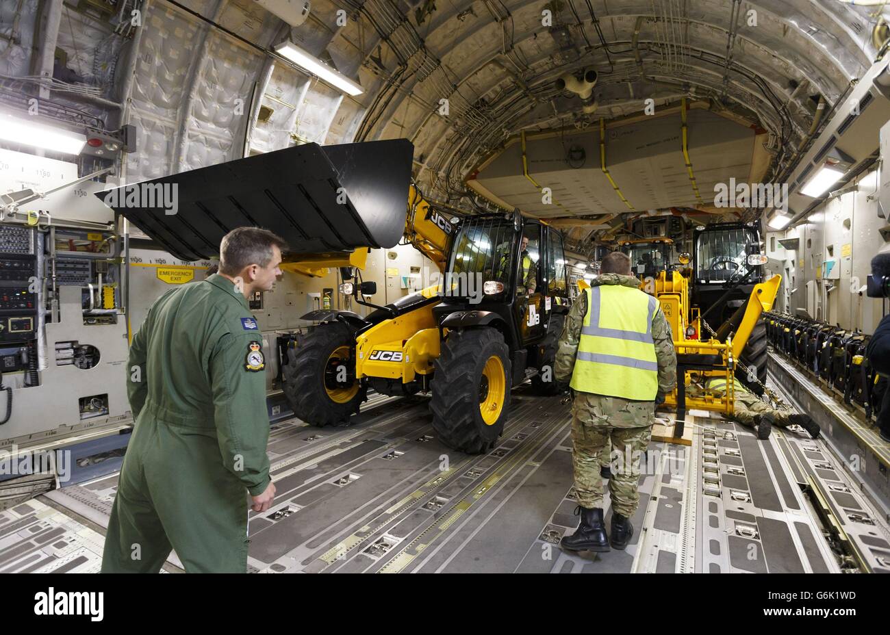 RAF ground crew load emergency supplies including JCB diggers and Land ...