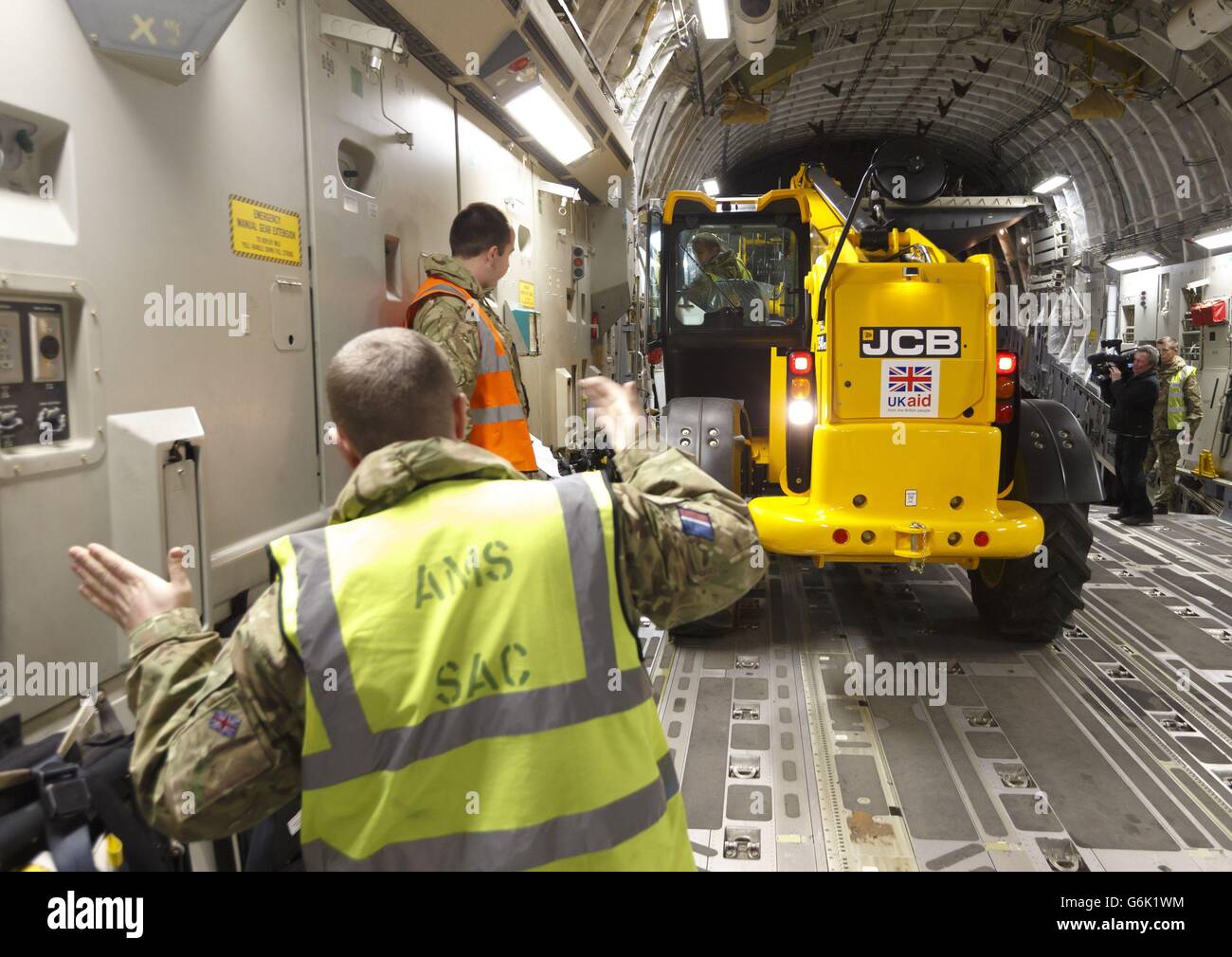 RAF ground crew load emergency supplies including JCB diggers and Land ...