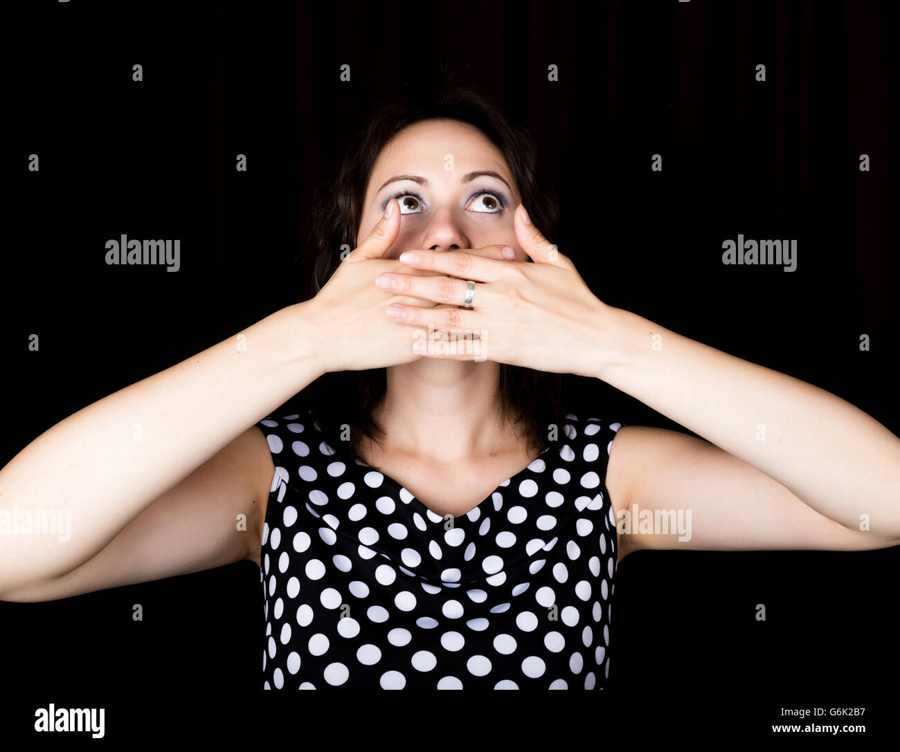 Close-up woman looks straight into the camera on a black background ...